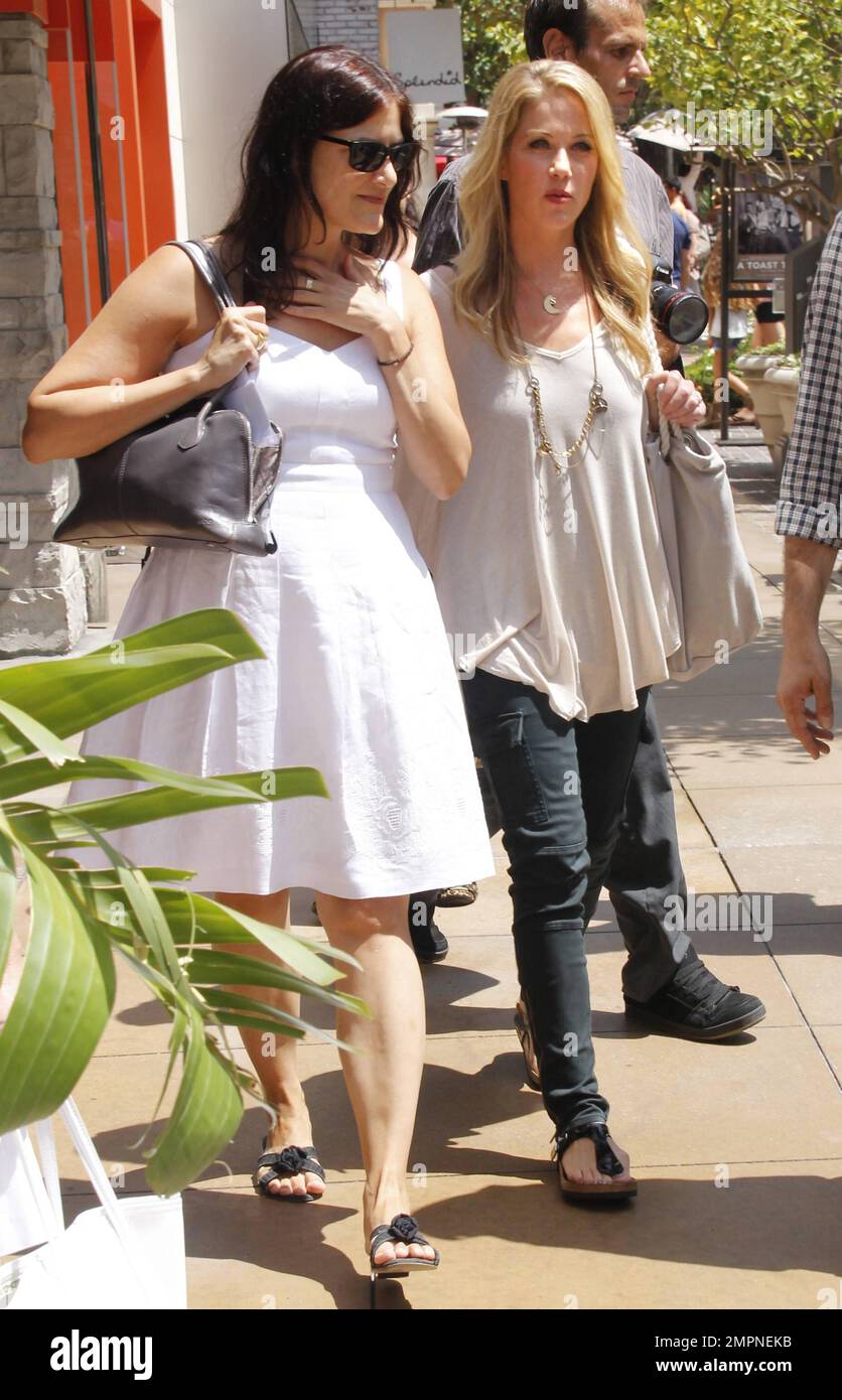 Wearing a loose tan top with black skinny jeans and sandals, Christina ...