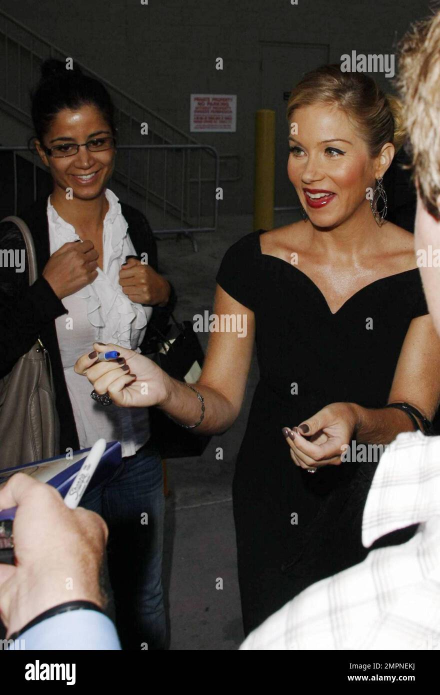 Wearing a simple black dress and sporting a short ponytail, Christina ...