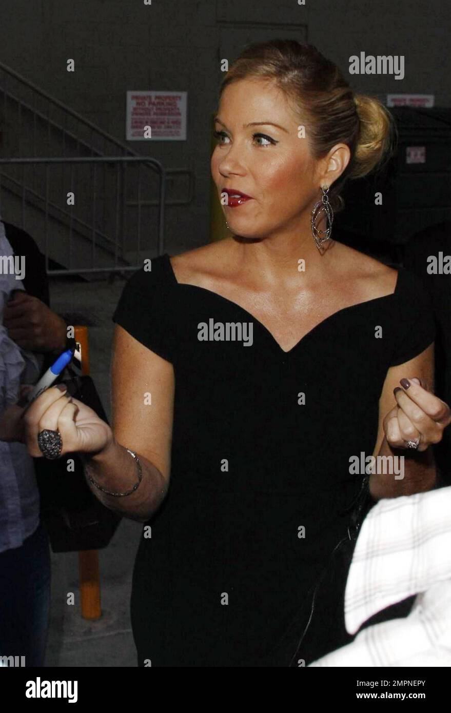 Wearing a simple black dress and sporting a short ponytail, Christina ...