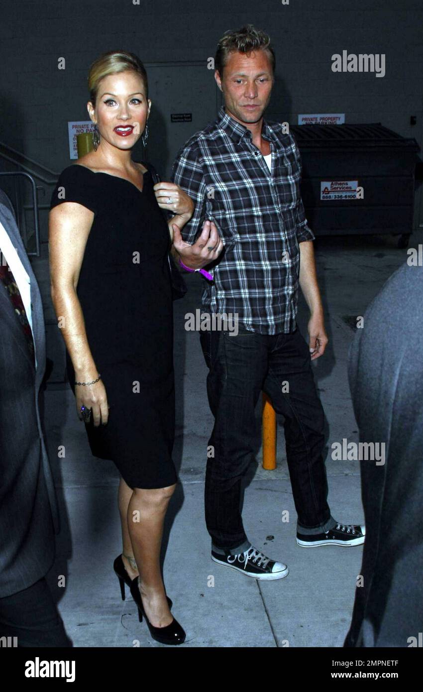 Wearing a simple black dress and sporting a short ponytail, Christina ...