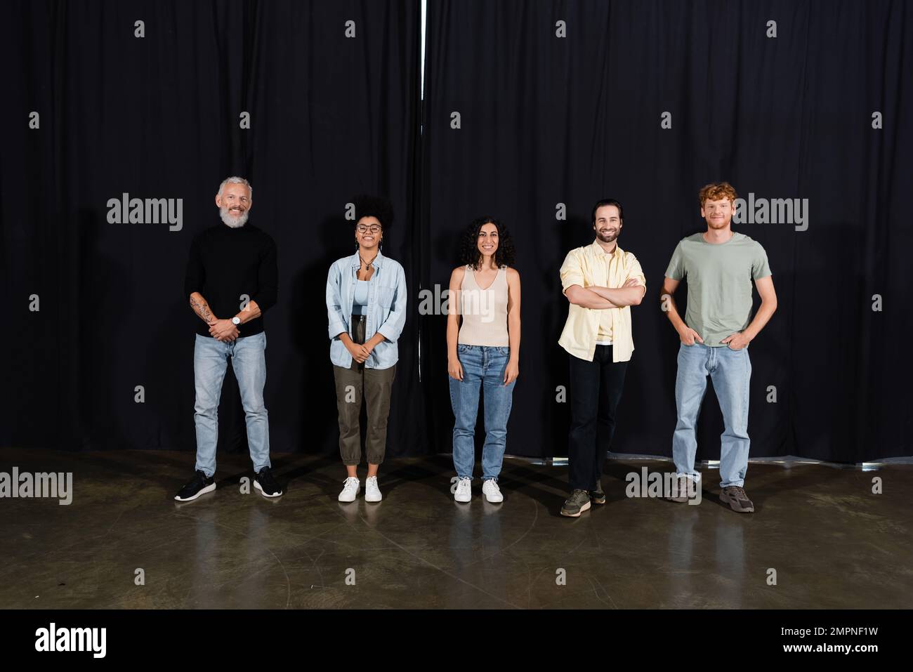 full length of happy art director with young multicultural actors ...