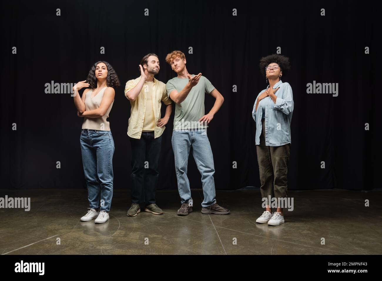 redhead man standing with hands on hips and pointing with hands near ...