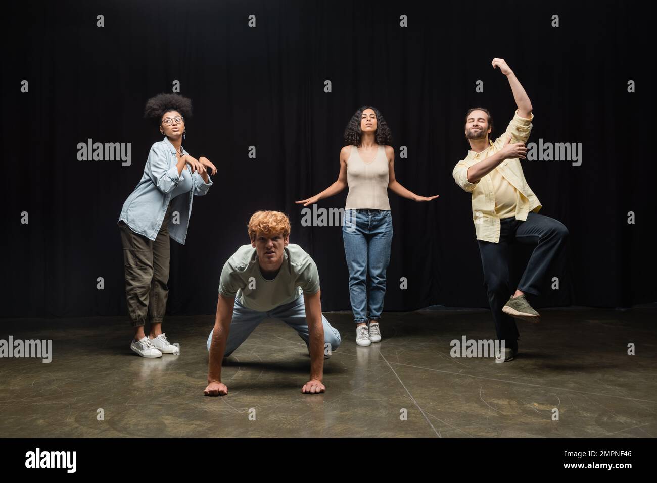 full length of multiethnic actors rehearsing in different poses on ...