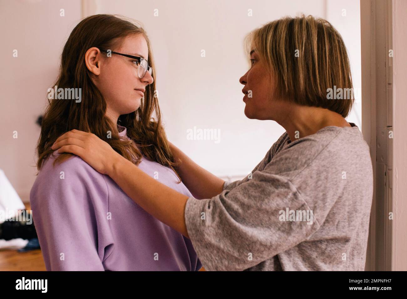 Side view of mother consoling daughter at home Stock Photo - Alamy