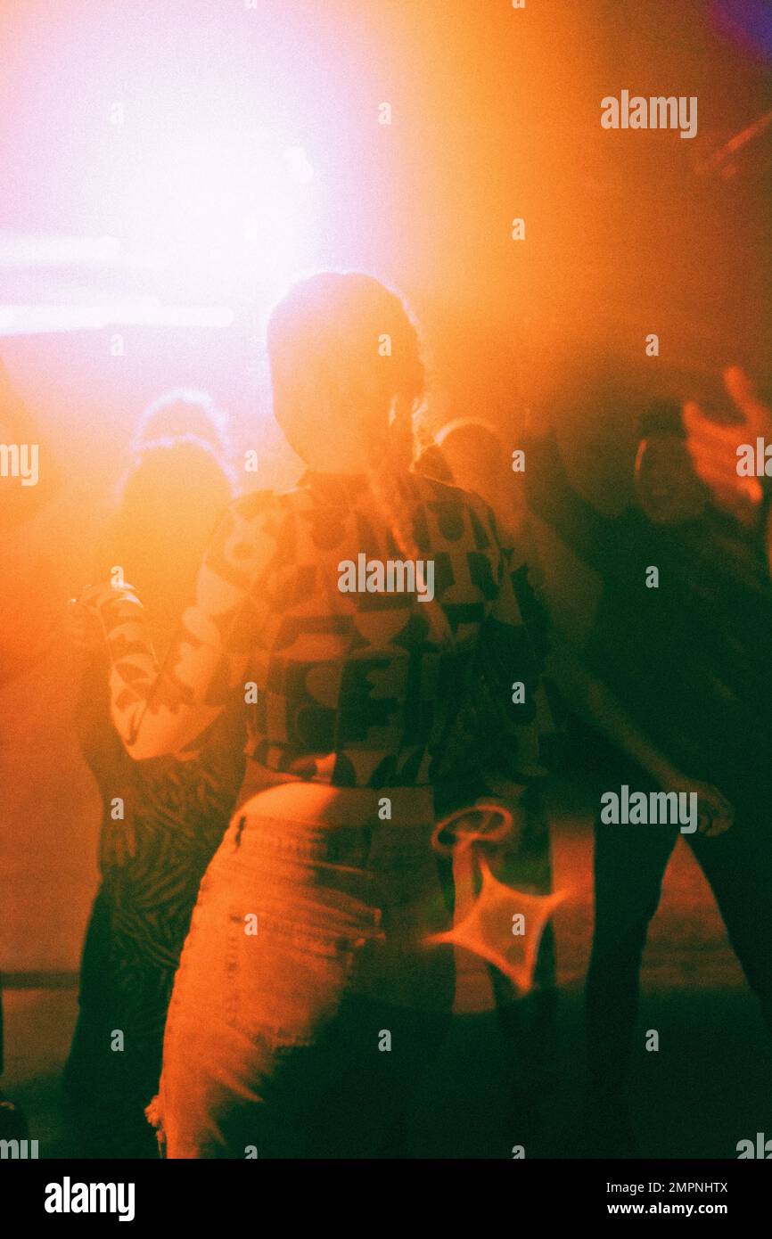 Back lit young woman dancing at illuminated nightclub Stock Photo - Alamy