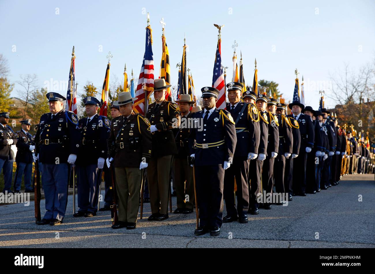 A collection of honor guards stand at attention before Baltimore Police ...