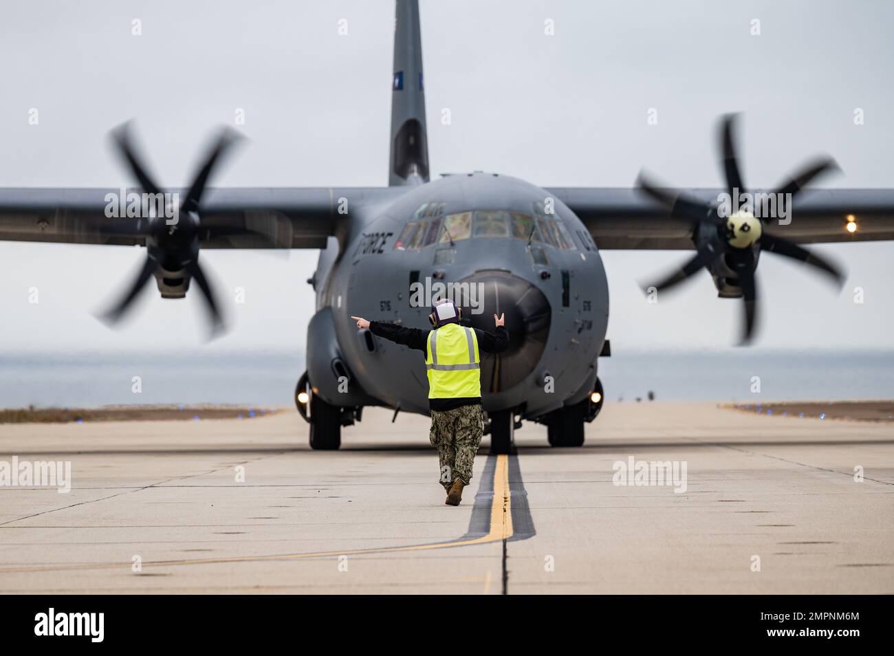 A U.S. Navy Sailor marshals a C-130J Hercules assigned to the 29th ...