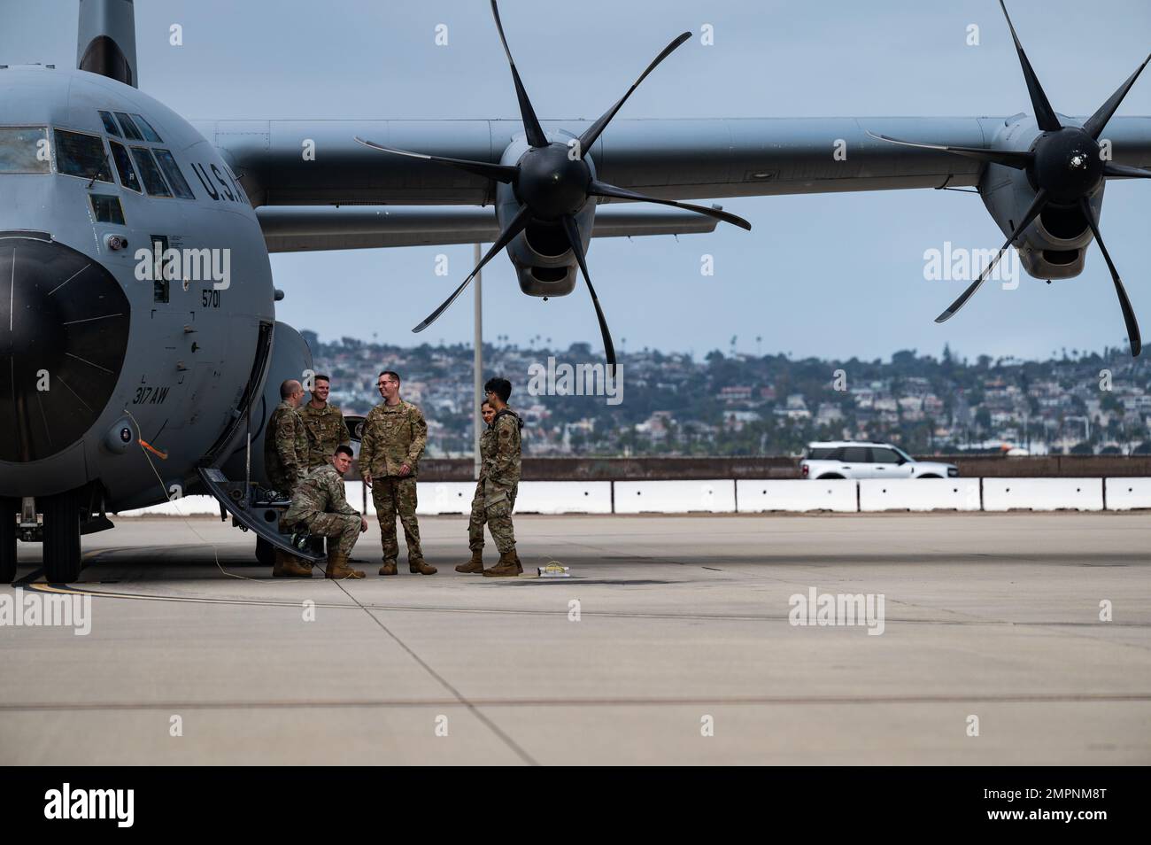 Airmen wait to board a C-130J Hercules assigned to the 29th Weapons ...