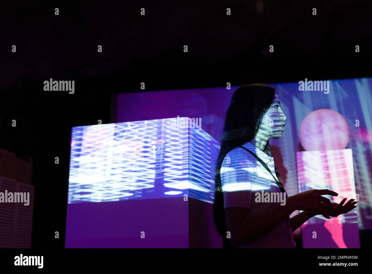 Side view of businesswoman gesturing by projection screen in ...