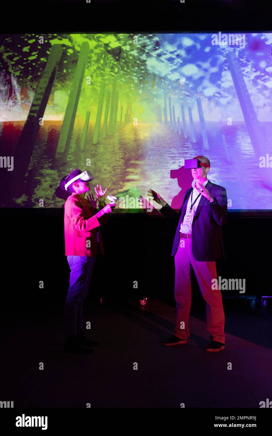 Multiracial colleagues with futuristic glasses gesturing by projection ...