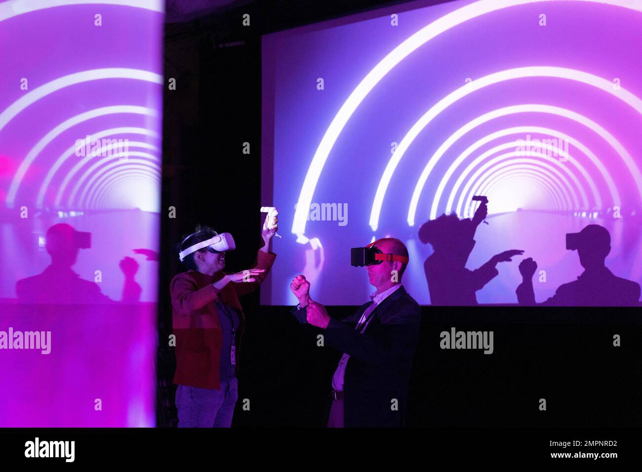 Colleagues with virtual reality glasses gesturing by projection screen ...