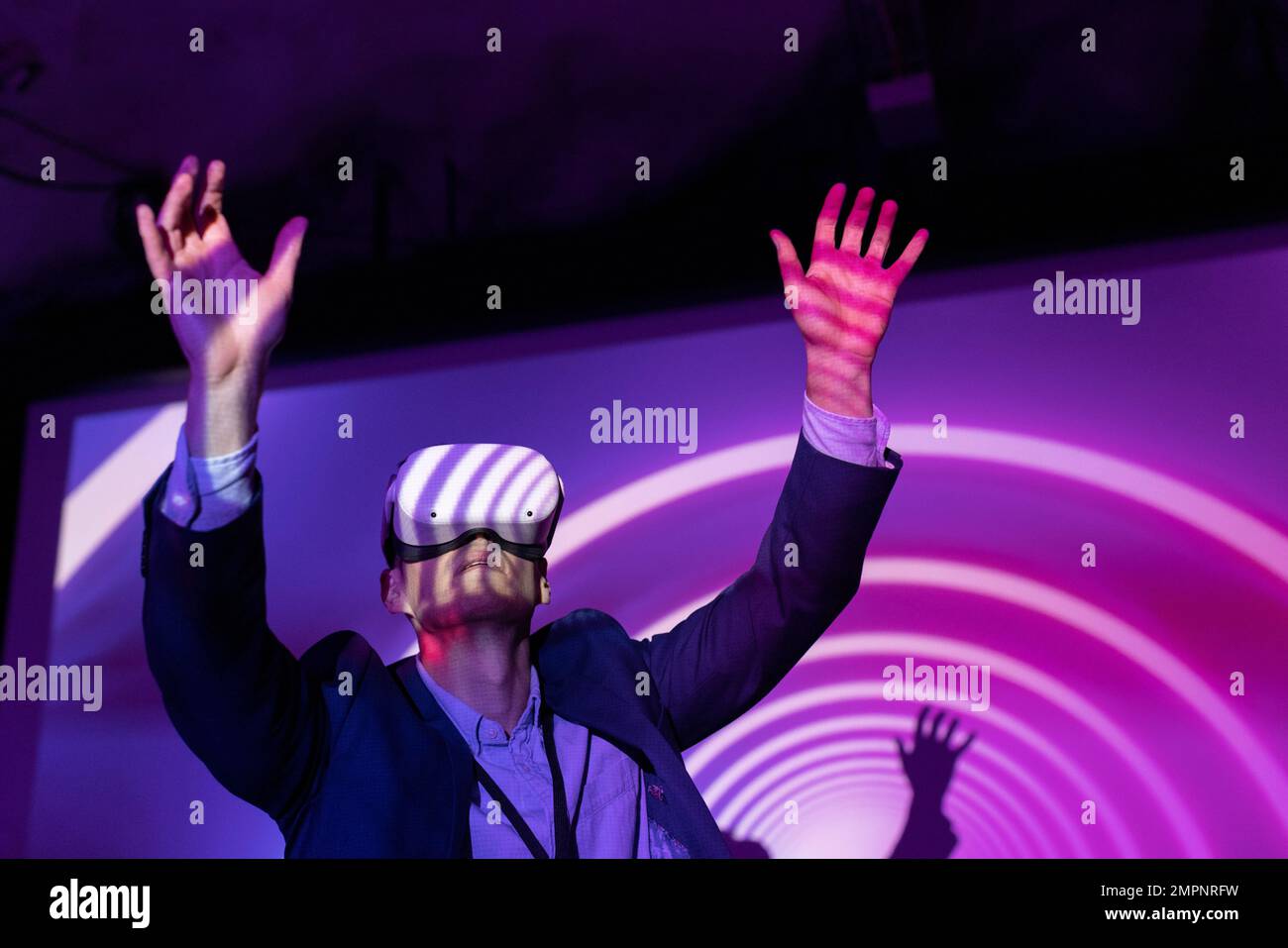 Male entrepreneur wearing VR glasses against projection screen in ...