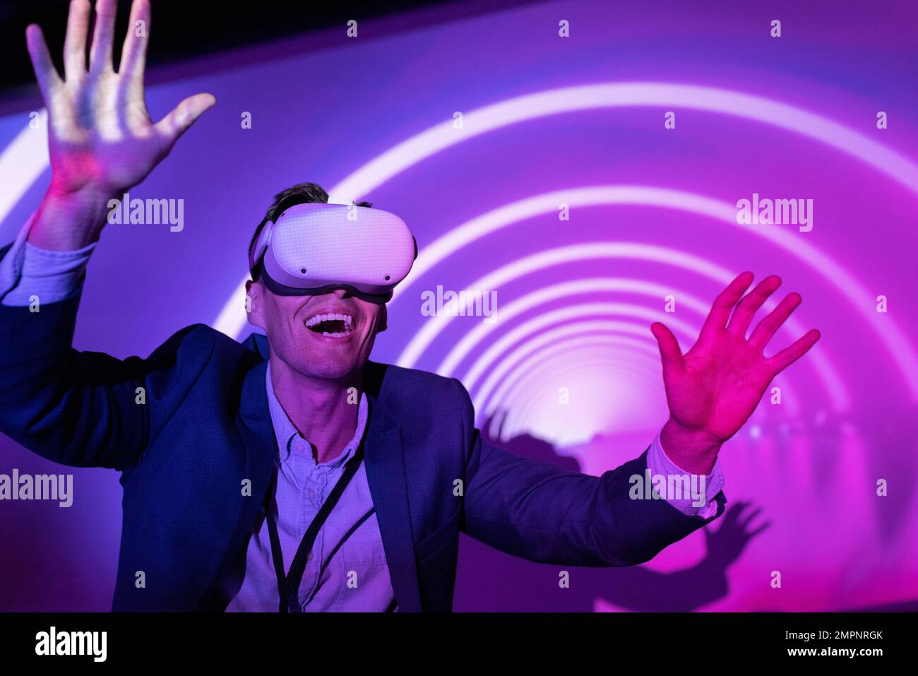 Cheerful businessman watching through futuristic glasses in front of ...