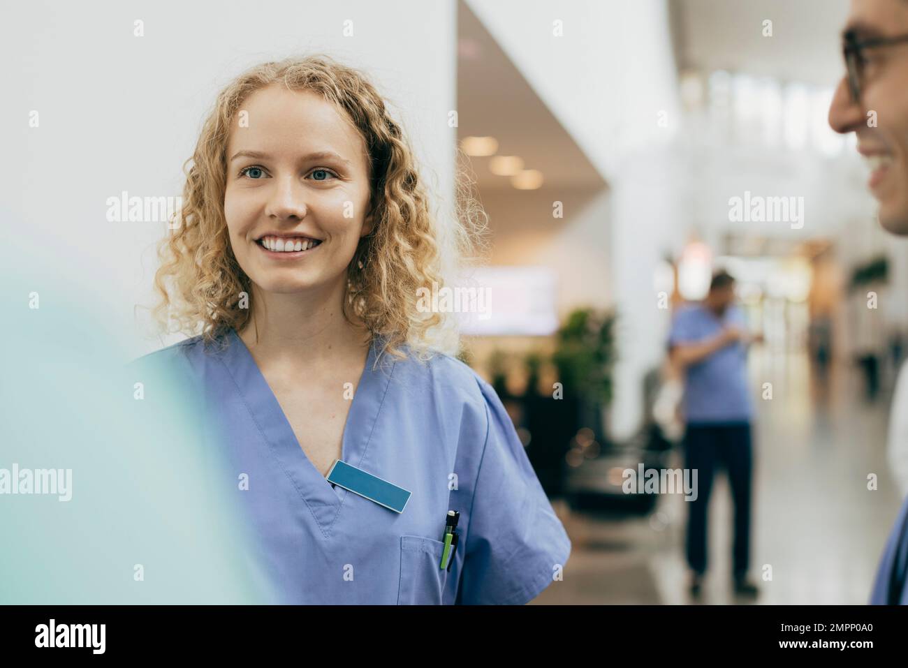 Smiling female healthcare staff with colleagues in hospital Stock Photo ...