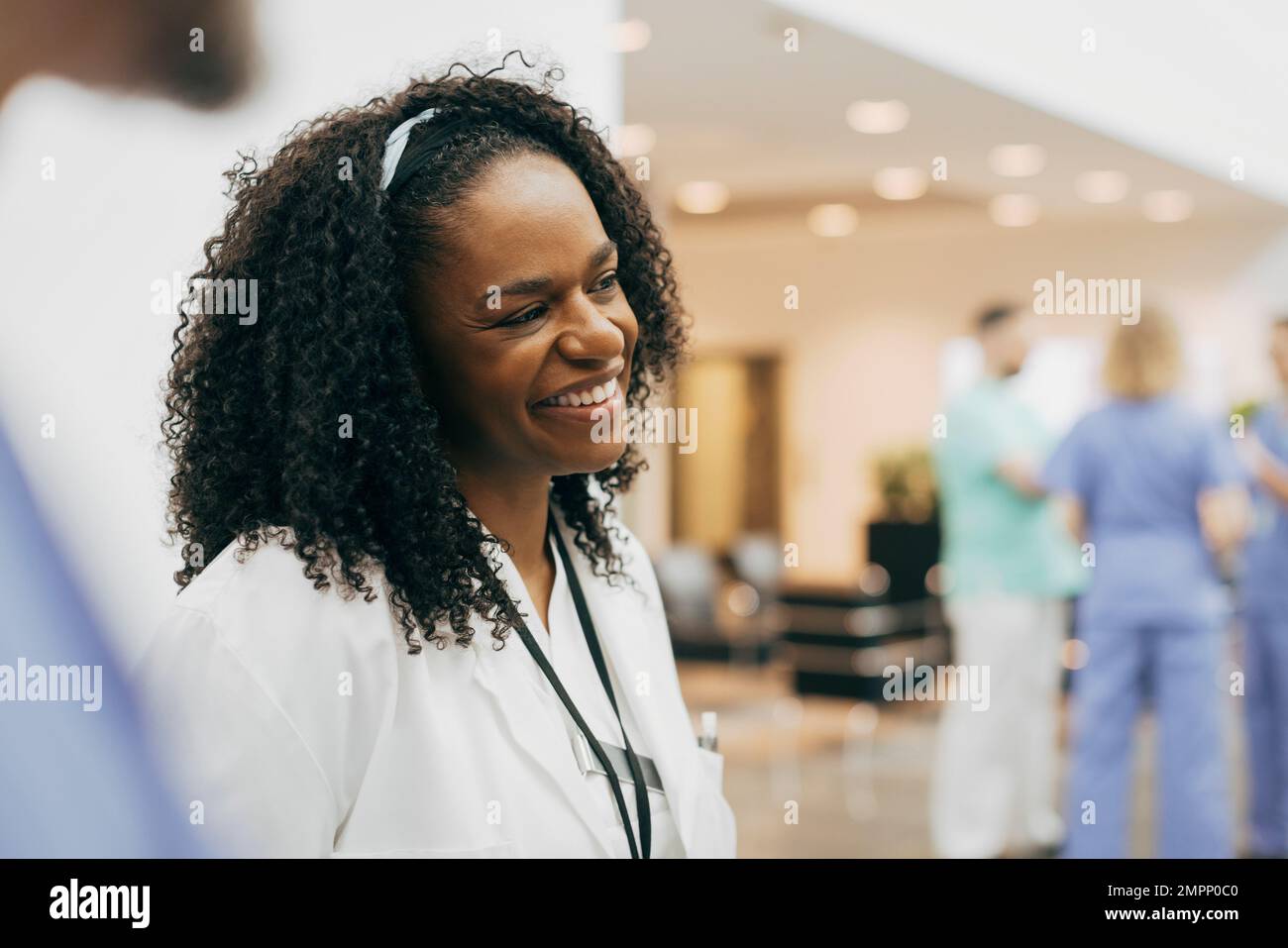 Happy female doctor with curly hair at hospital Stock Photo - Alamy
