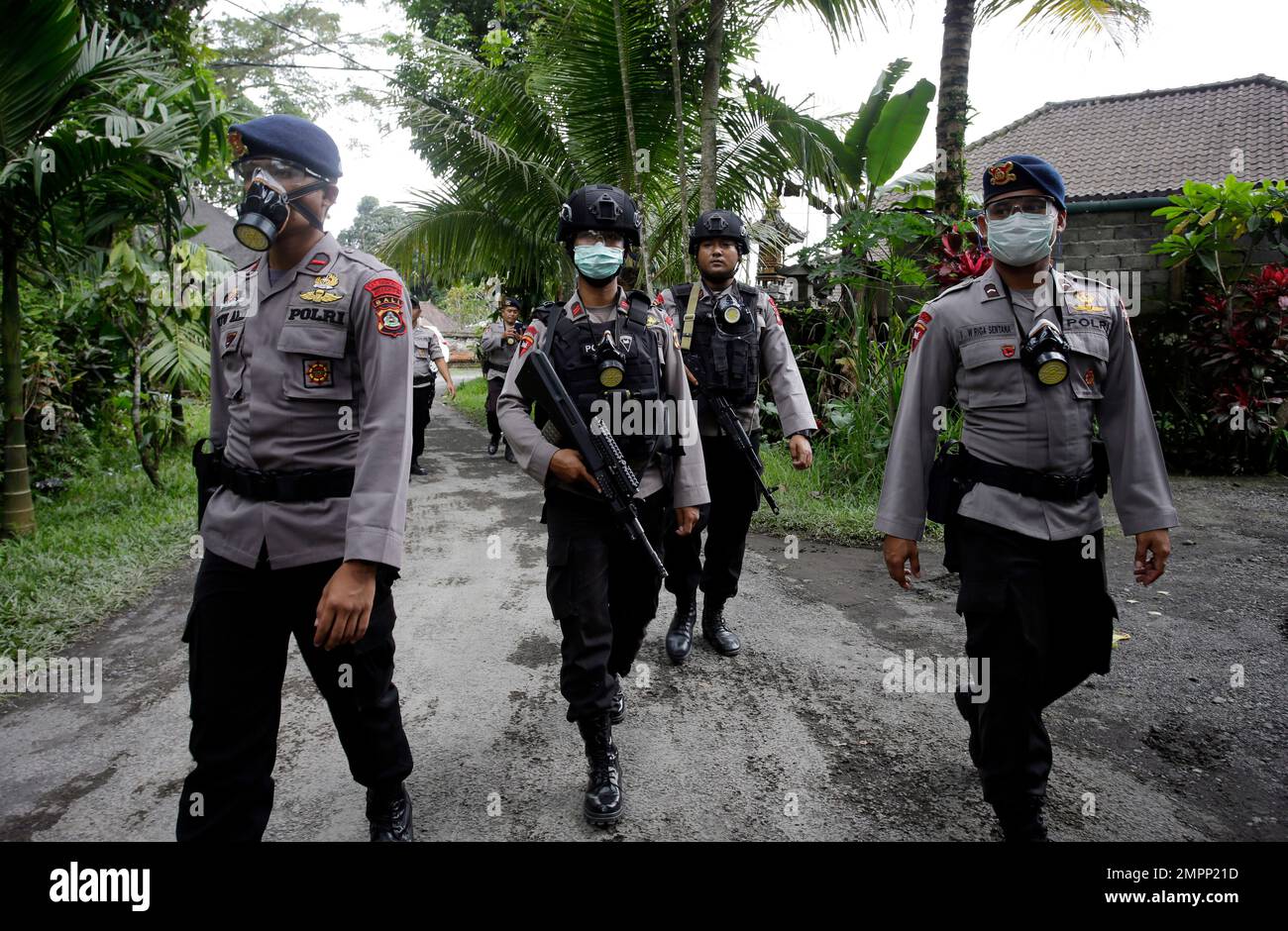 Police officers wear masks as they patrol in a village in Karangasem ...
