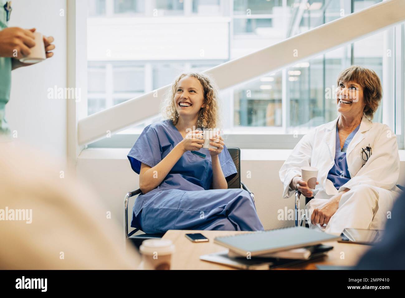 Happy female healthcare workers having coffee during break in hospital ...