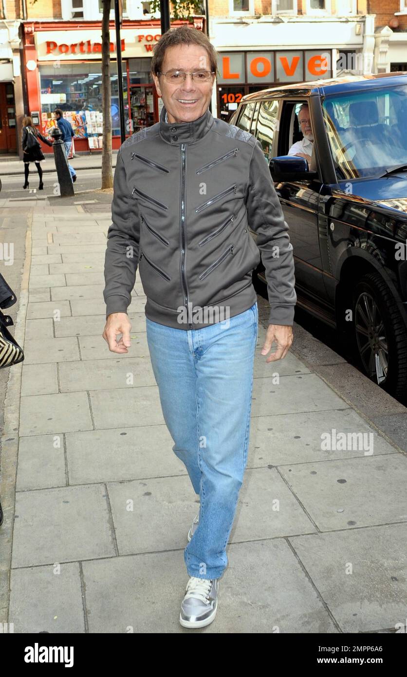 Sir Cliff Richard signs an autograph for a young fan while making an ...