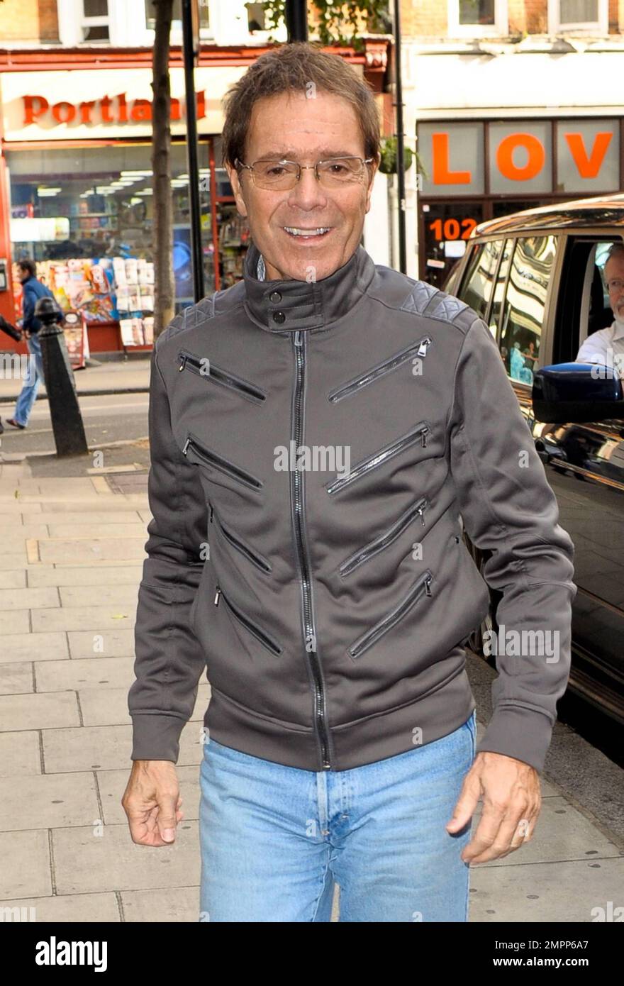 Sir Cliff Richard signs an autograph for a young fan while making an ...