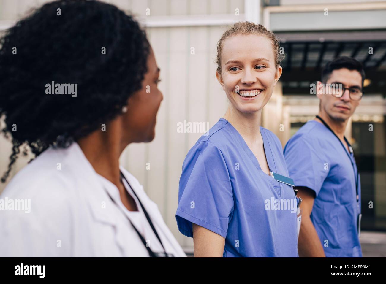 Happy female nurse talking with doctor outside hospital Stock Photo - Alamy