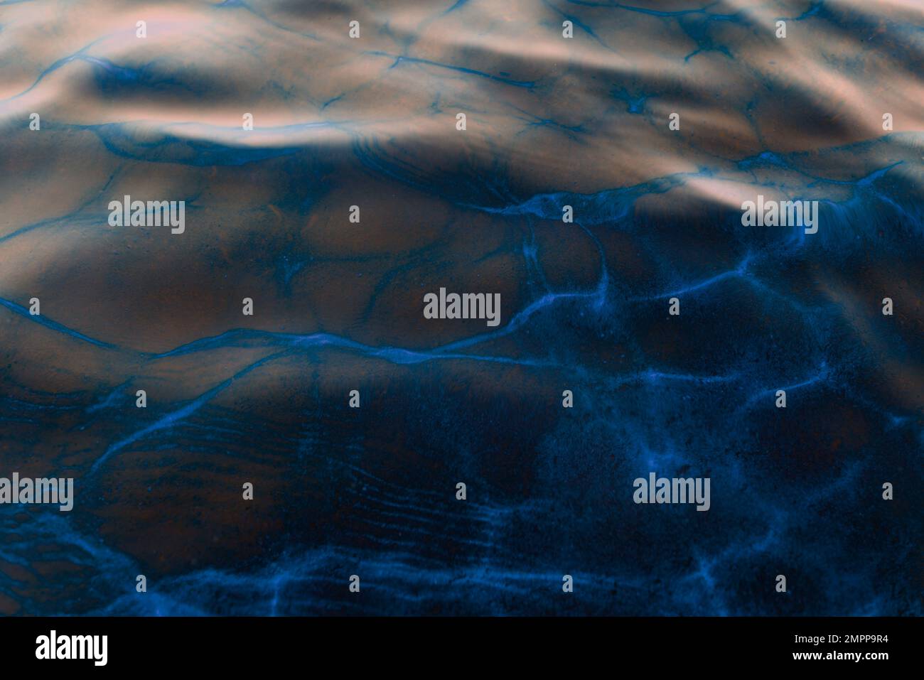 Abstract photo of glowing water surface with dark blue light reflection ...