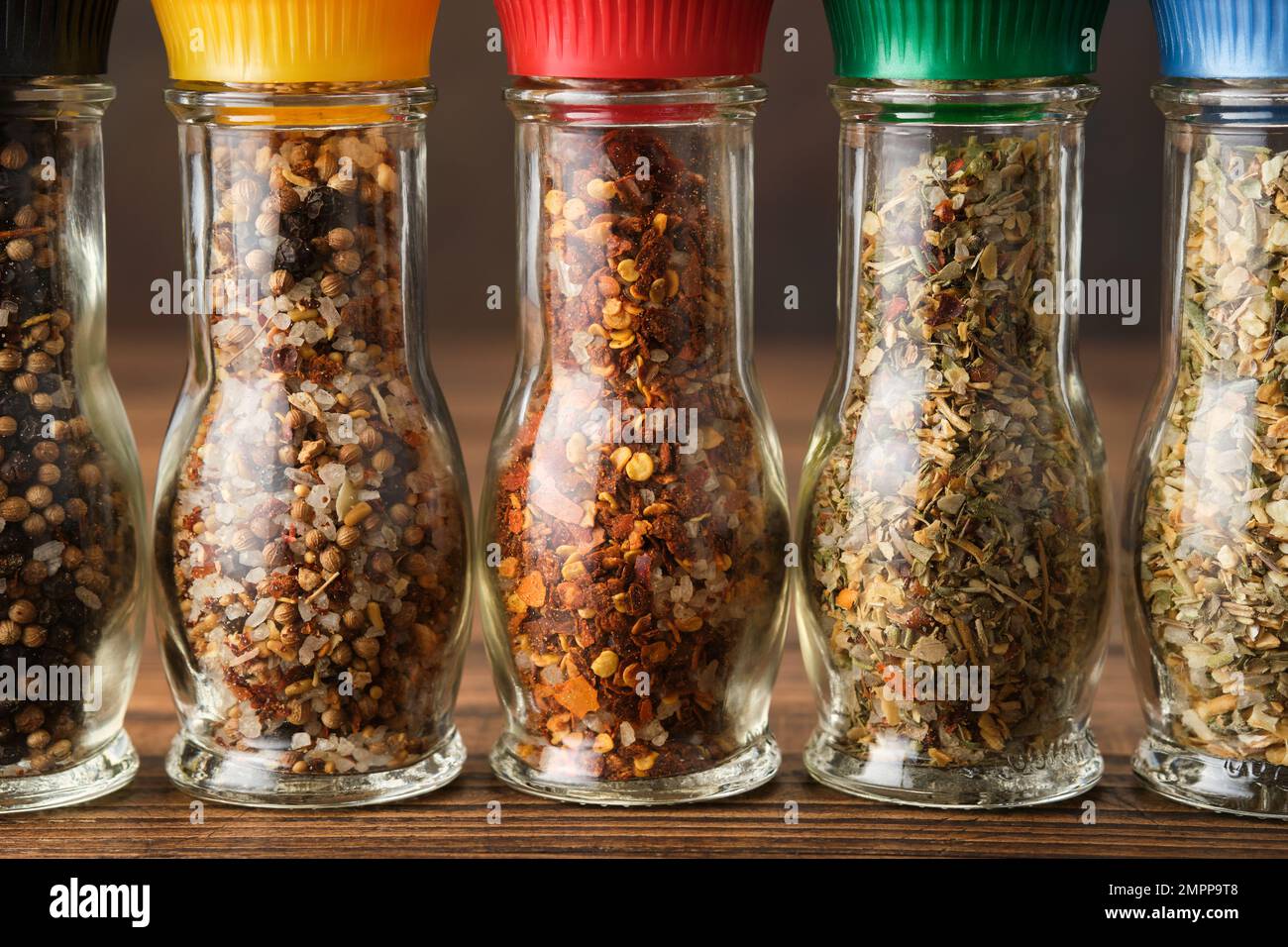 Glass mills with aromatic spices and herbs. Several grinders of ...