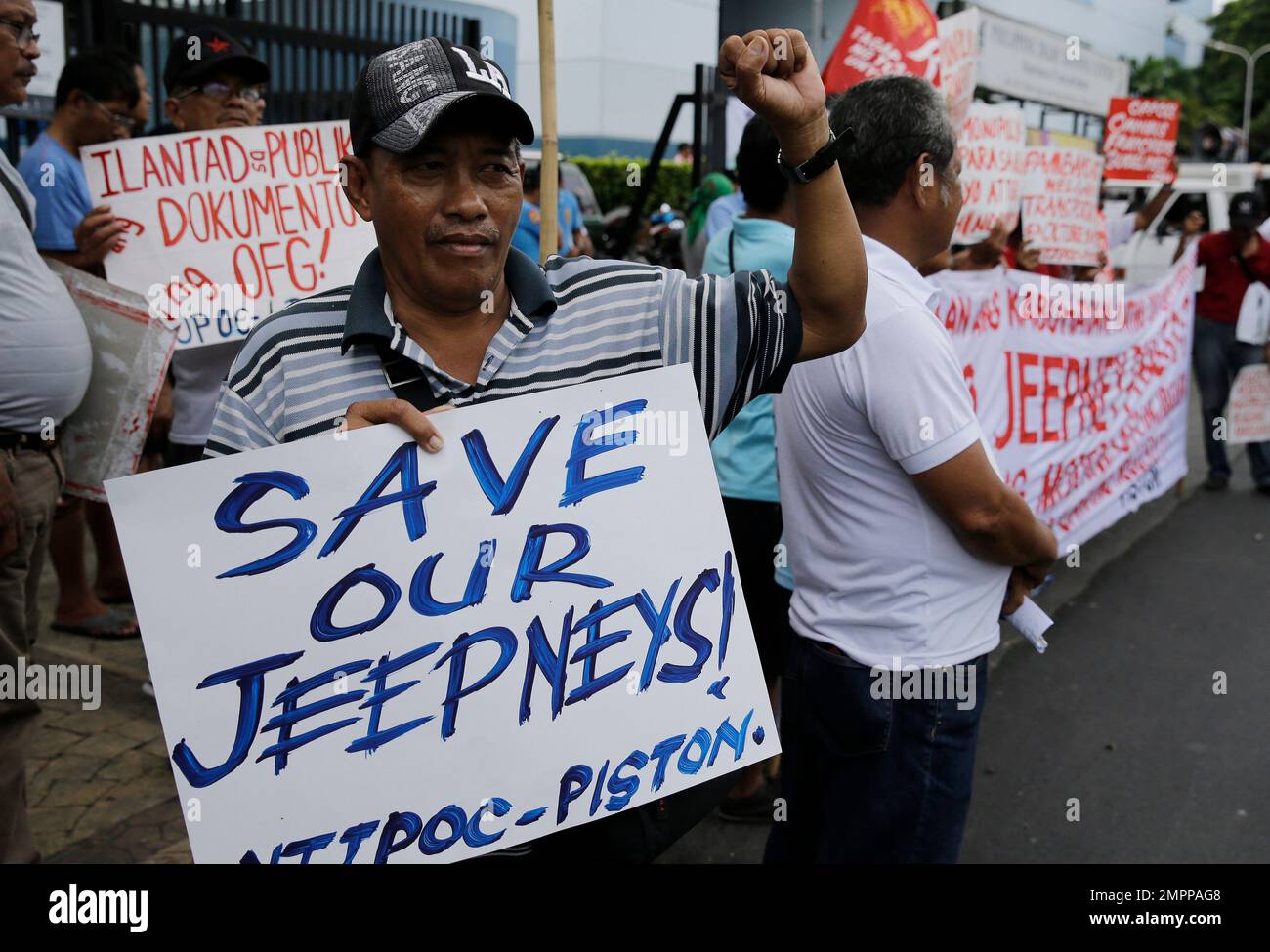 In this Oct. 12, 2017, photo, a Filipino jeepney driver holds a sign ...