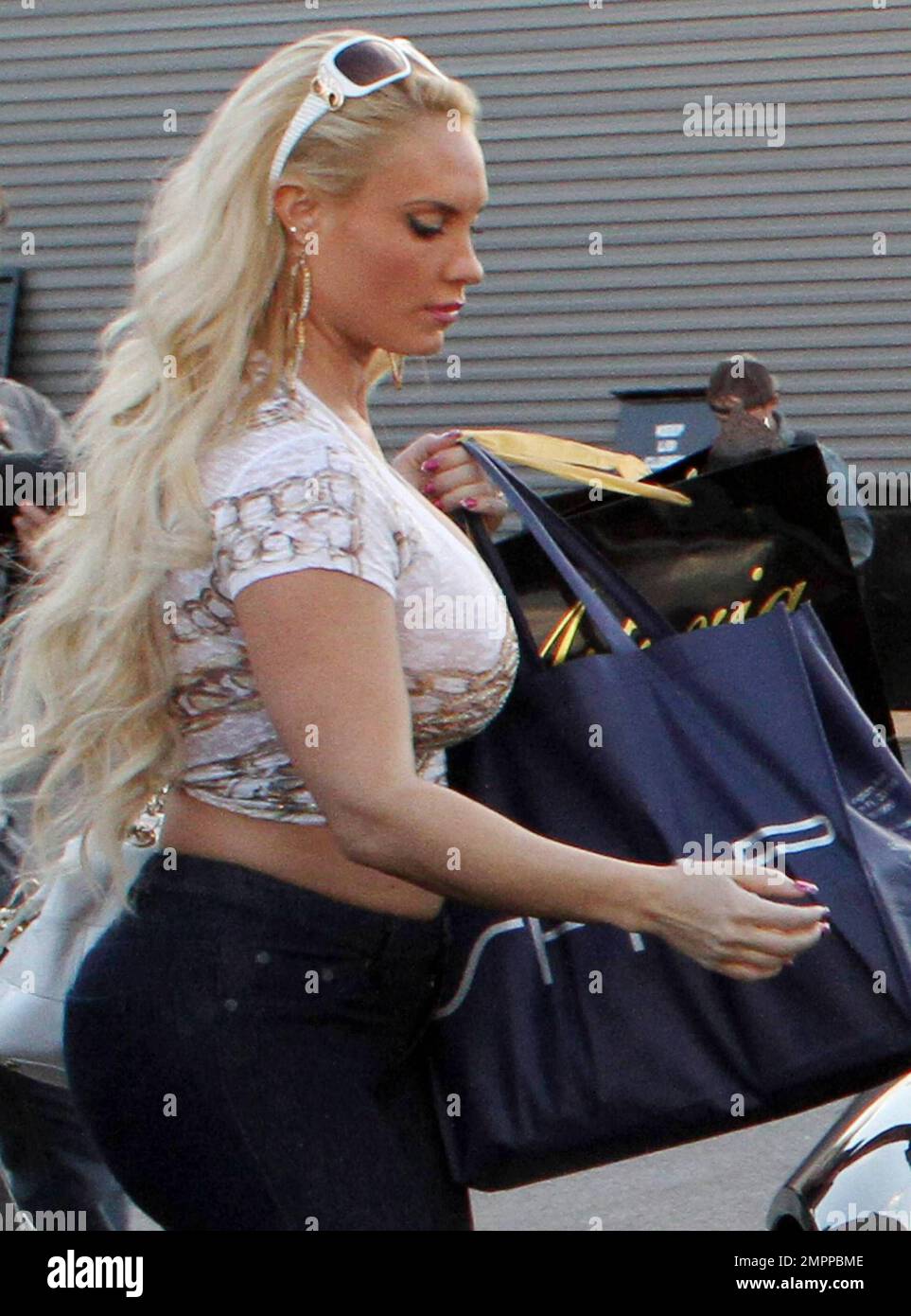 Showing off her famous curves in super tight jeans and a tiny belly top ...