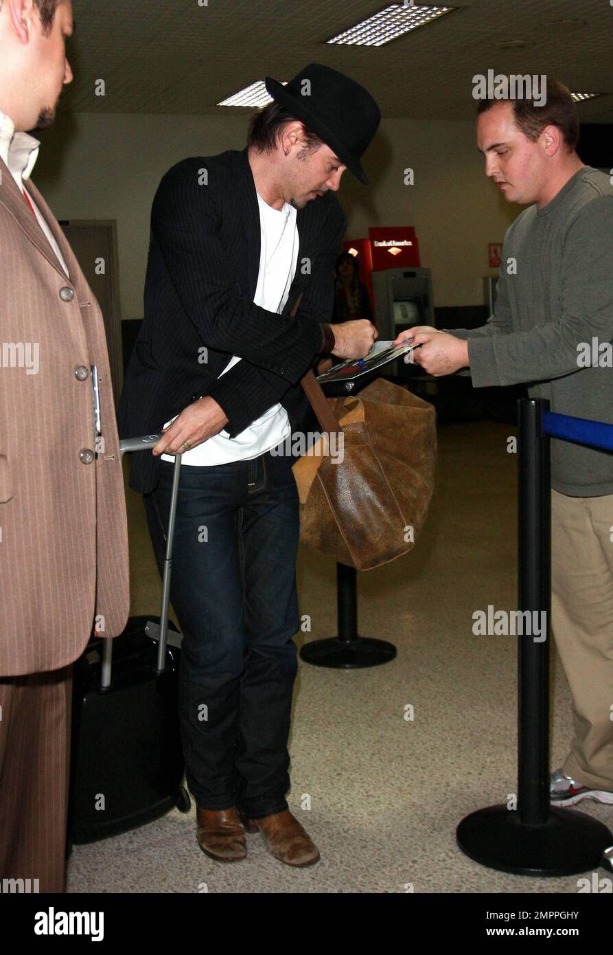 Colin Farrell signs autographs as he makes his way through the terminal ...