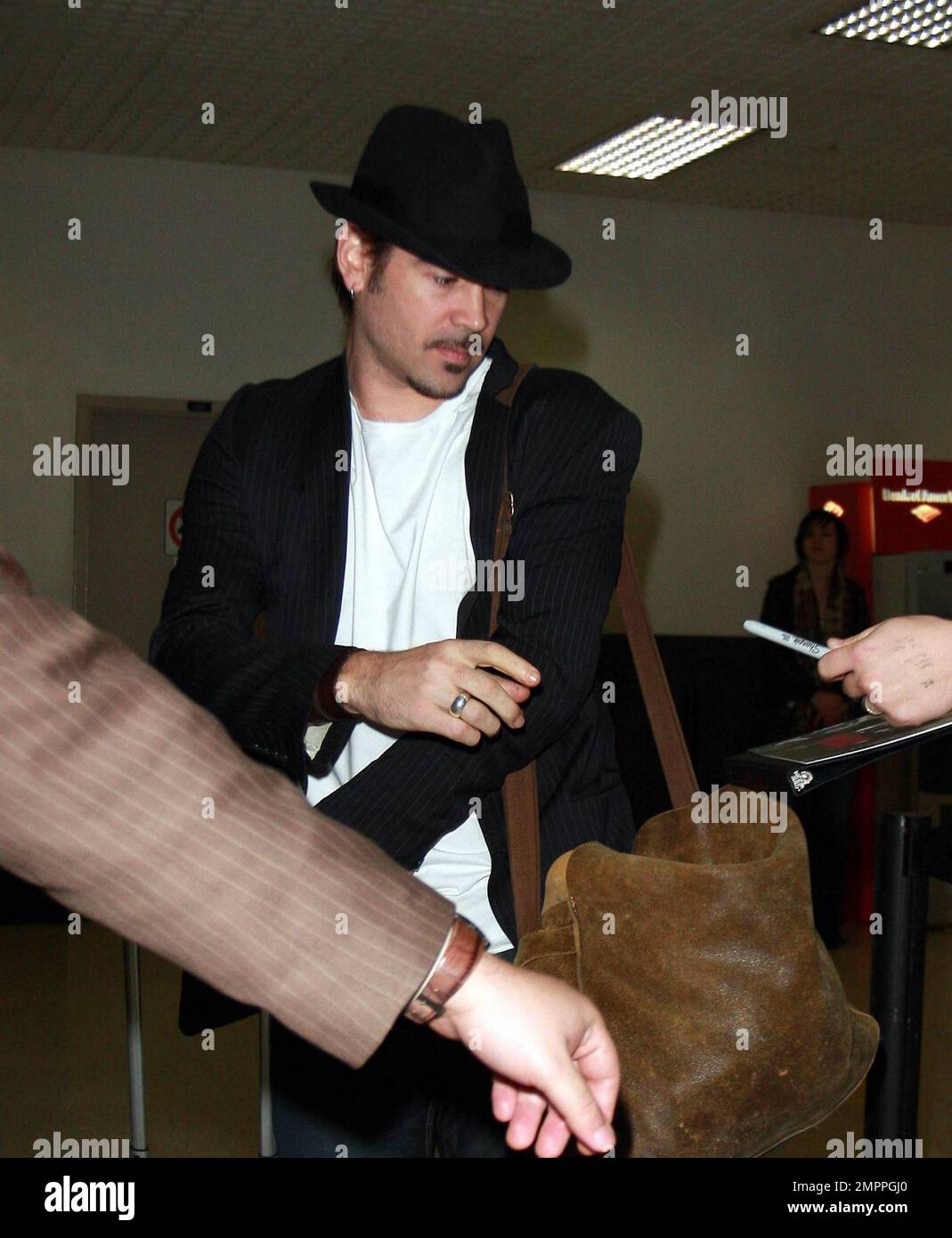 Colin Farrell signs autographs as he makes his way through the terminal ...