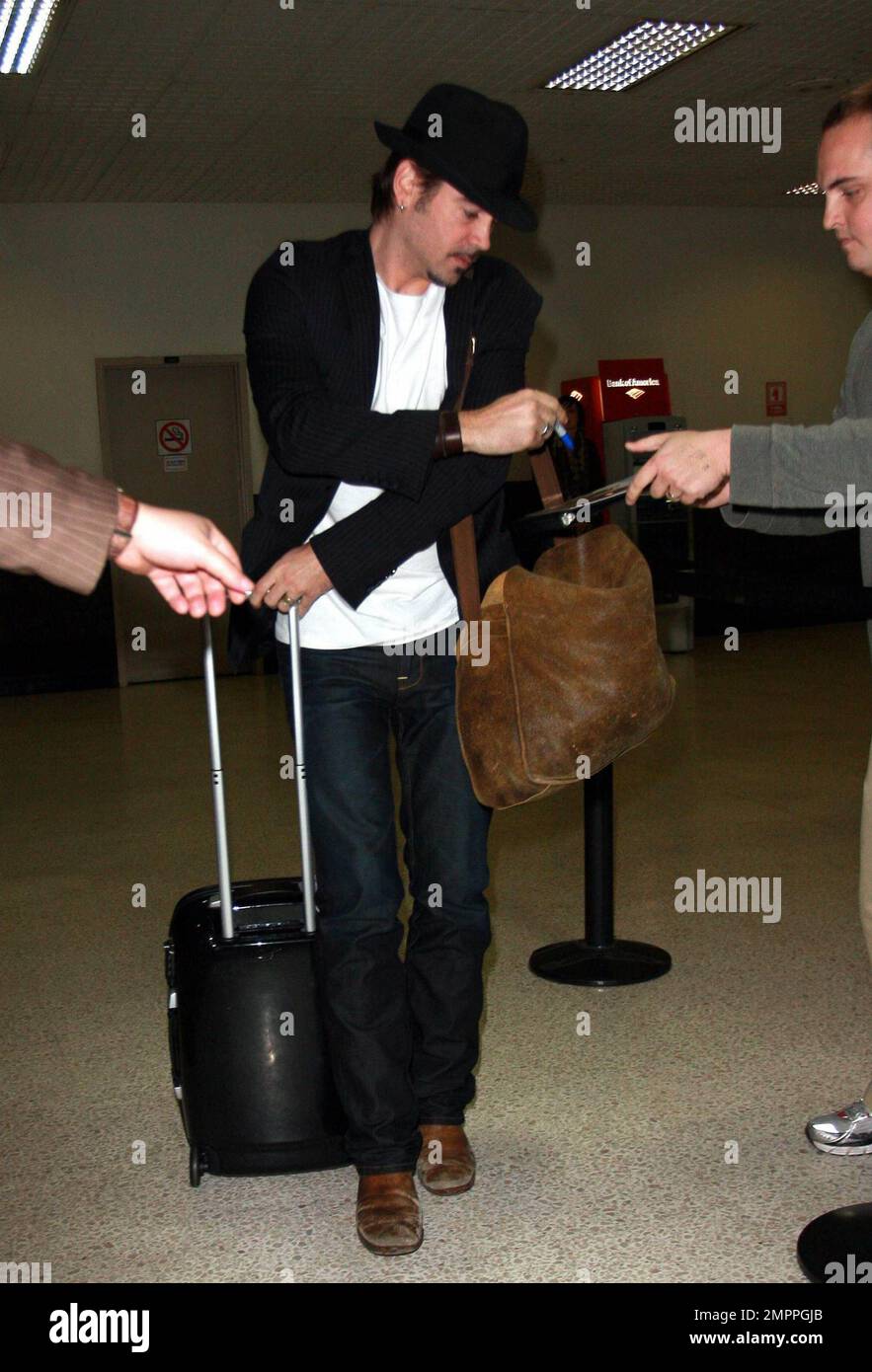 Colin Farrell signs autographs as he makes his way through the terminal ...