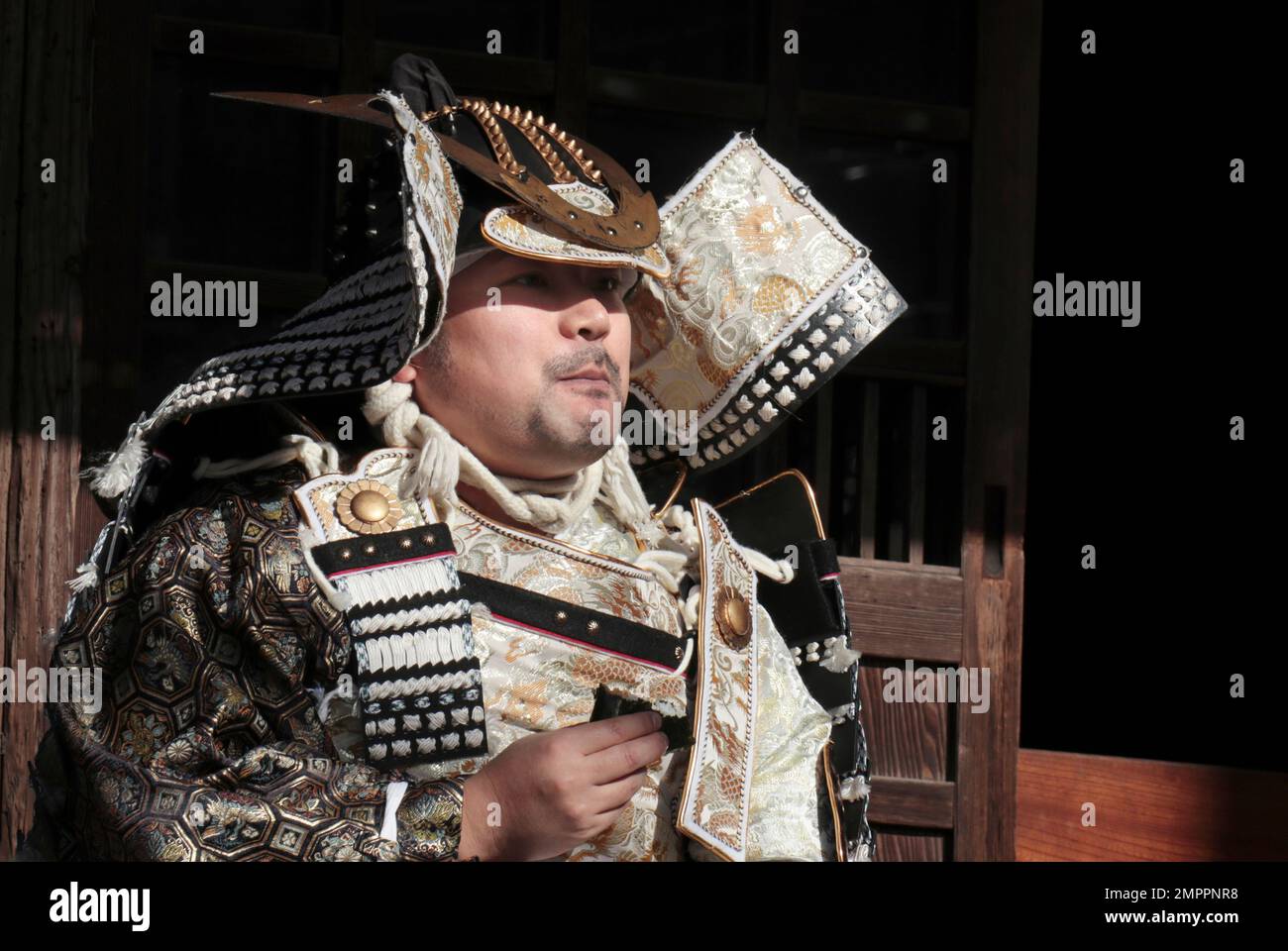 A participant wearing outfits of traditional Japanese "samurai" eats a ...
