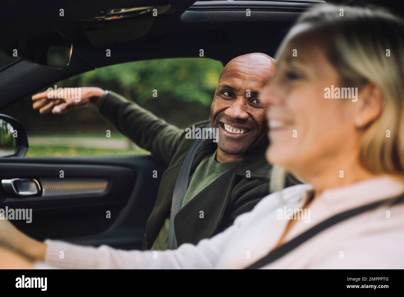 Happy bald man looking at woman driving car Stock Photo - Alamy