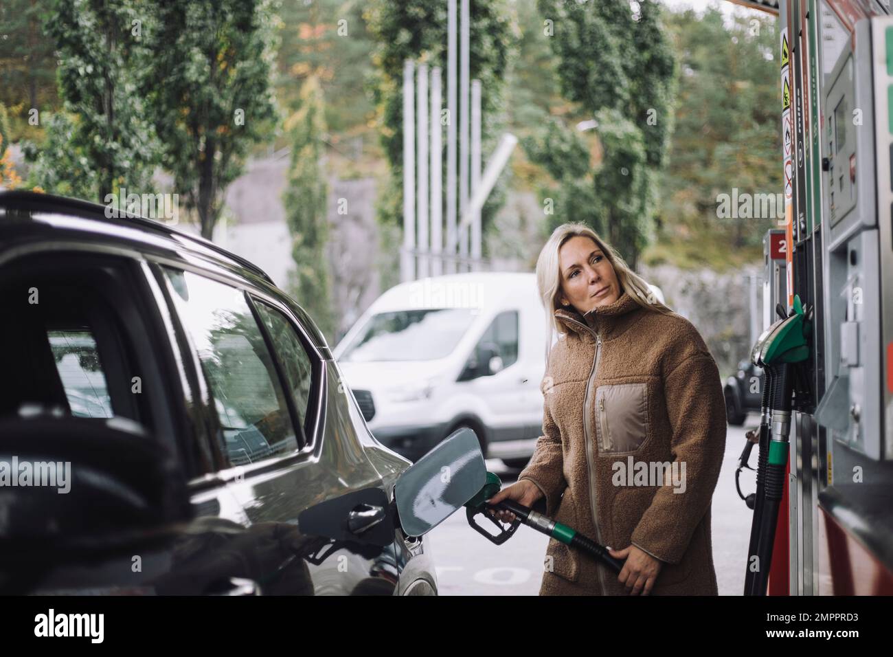 Mature woman pumping gas hi-res stock photography and images - Alamy