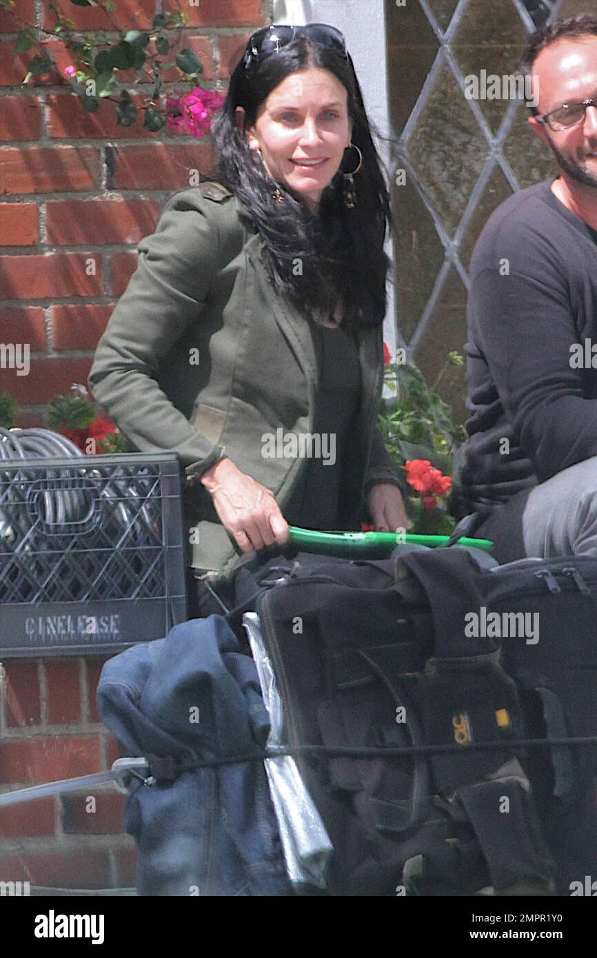 Courteney Cox looks to be wearing no makeup as she works on her script ...