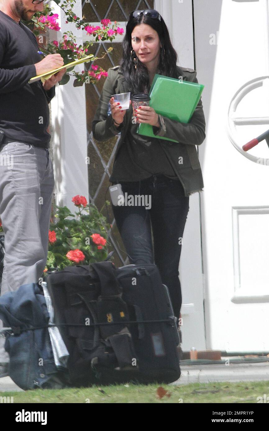 Courteney Cox looks to be wearing no makeup as she works on her script ...
