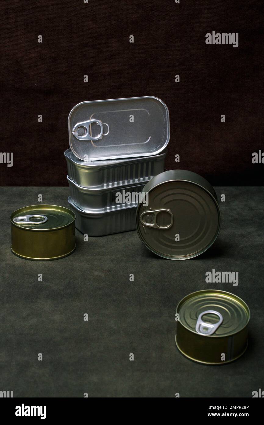Seven iron cans of canned food on a green table Stock Photo - Alamy