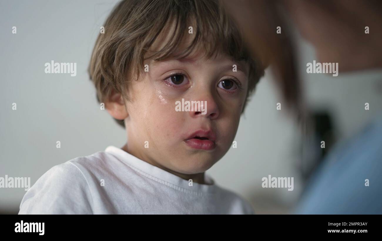 Portrait of a tearful child crying. Closeup face of a sad little boy. Authentic real life kid ...