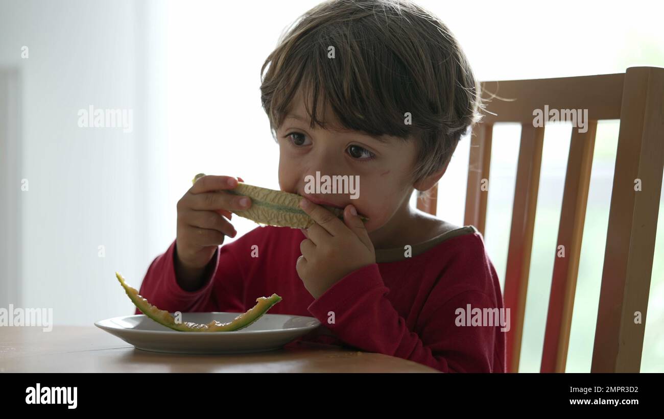 One small boy eating fruit snack in morning breakfast Stock Photo - Alamy