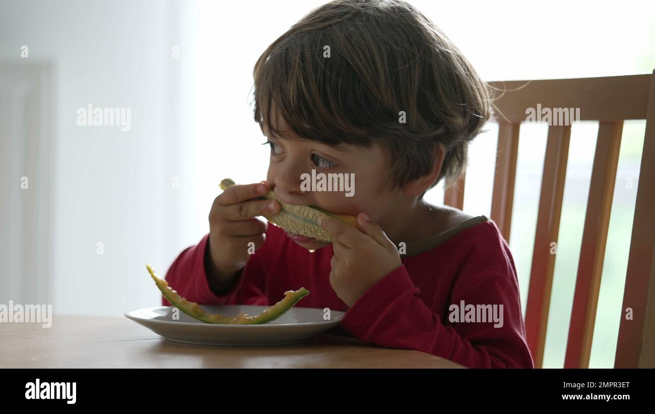 One small boy eating fruit snack in morning breakfast Stock Photo - Alamy
