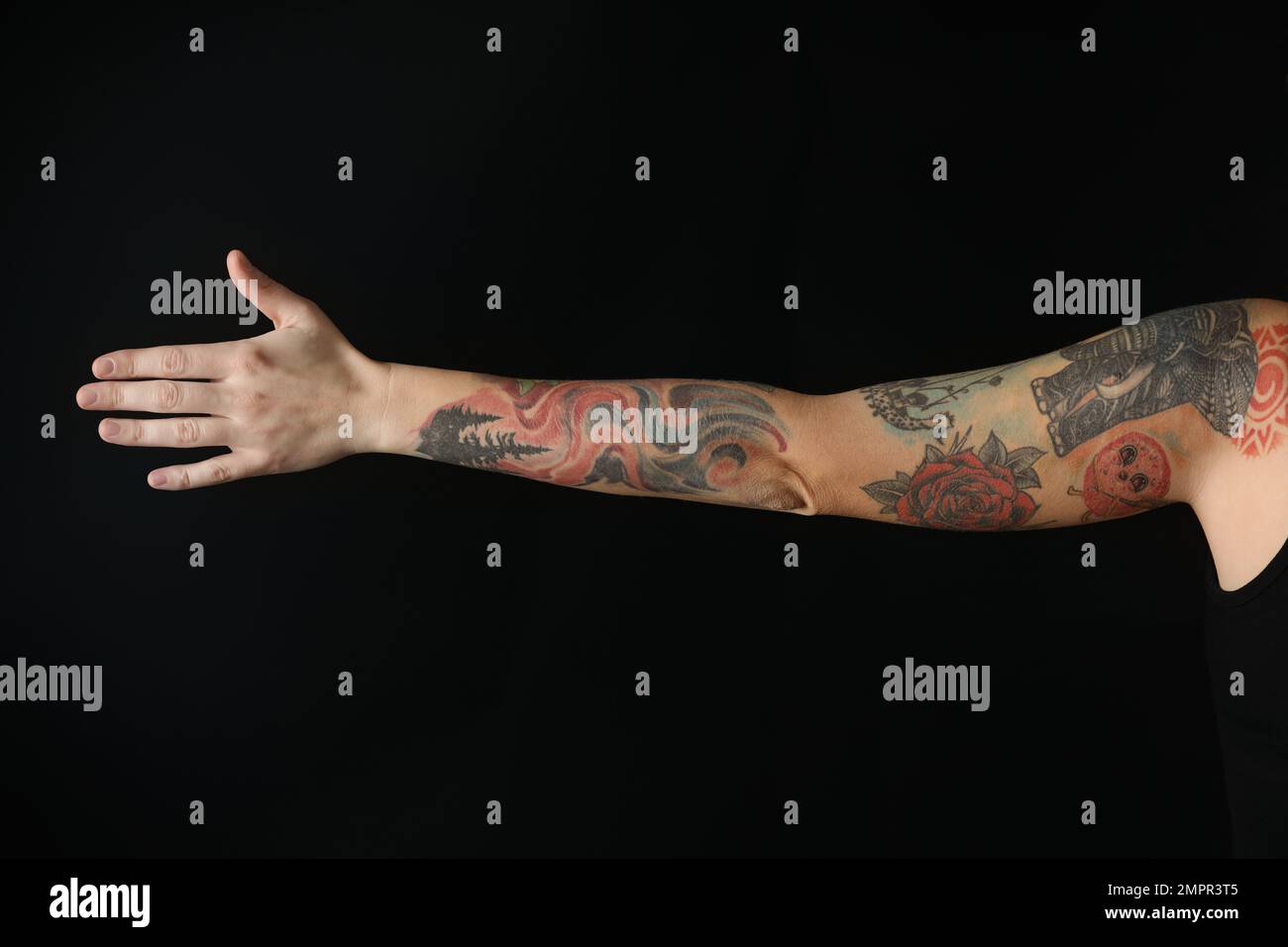 Woman with stylish tattoos on arm against black background, closeup ...