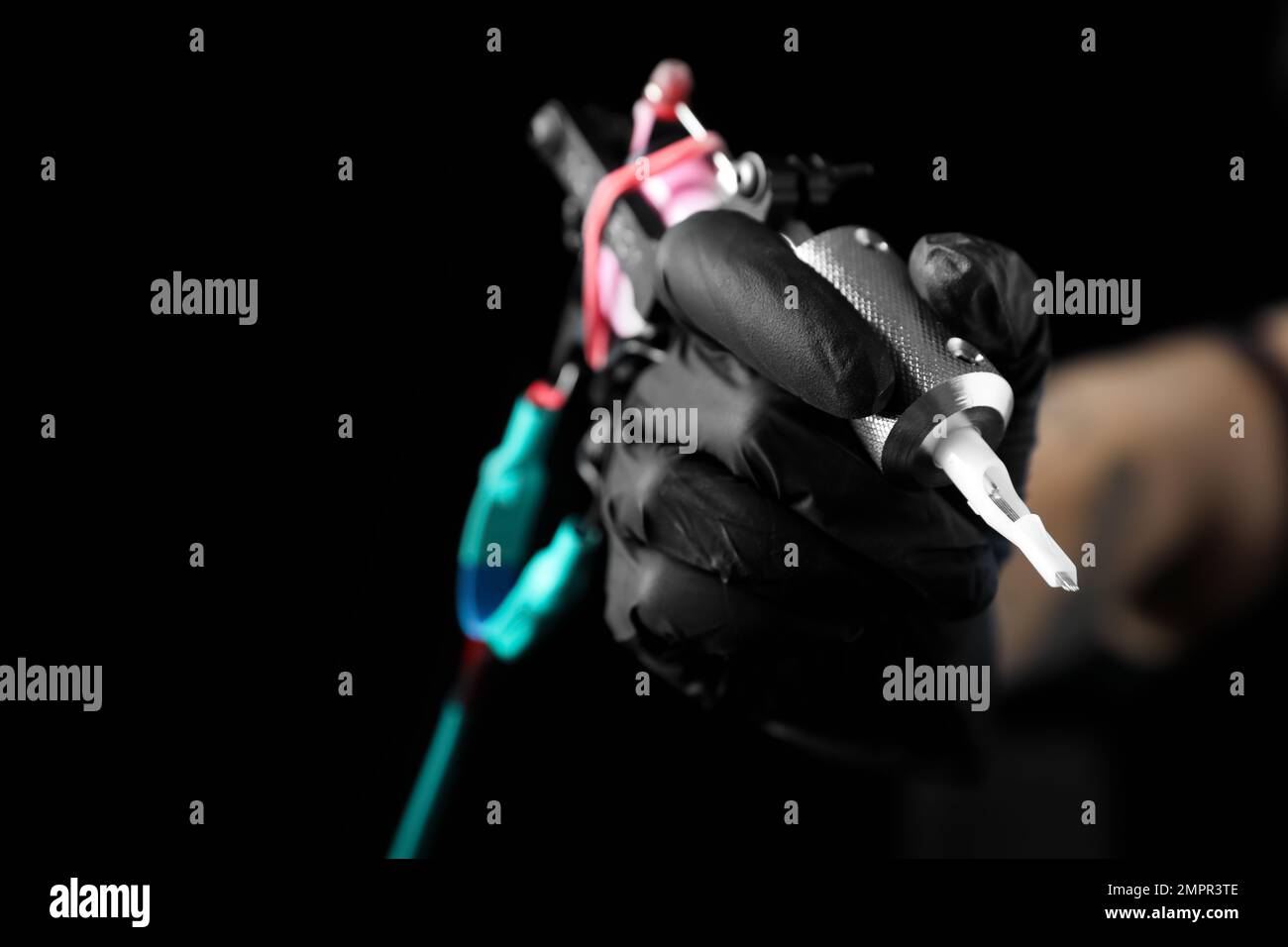 Tattoo artist with professional machine on black background, closeup ...