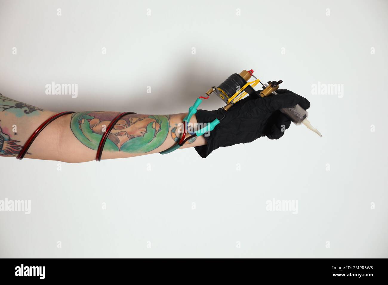 Tattoo artist with professional machine on white background, closeup ...