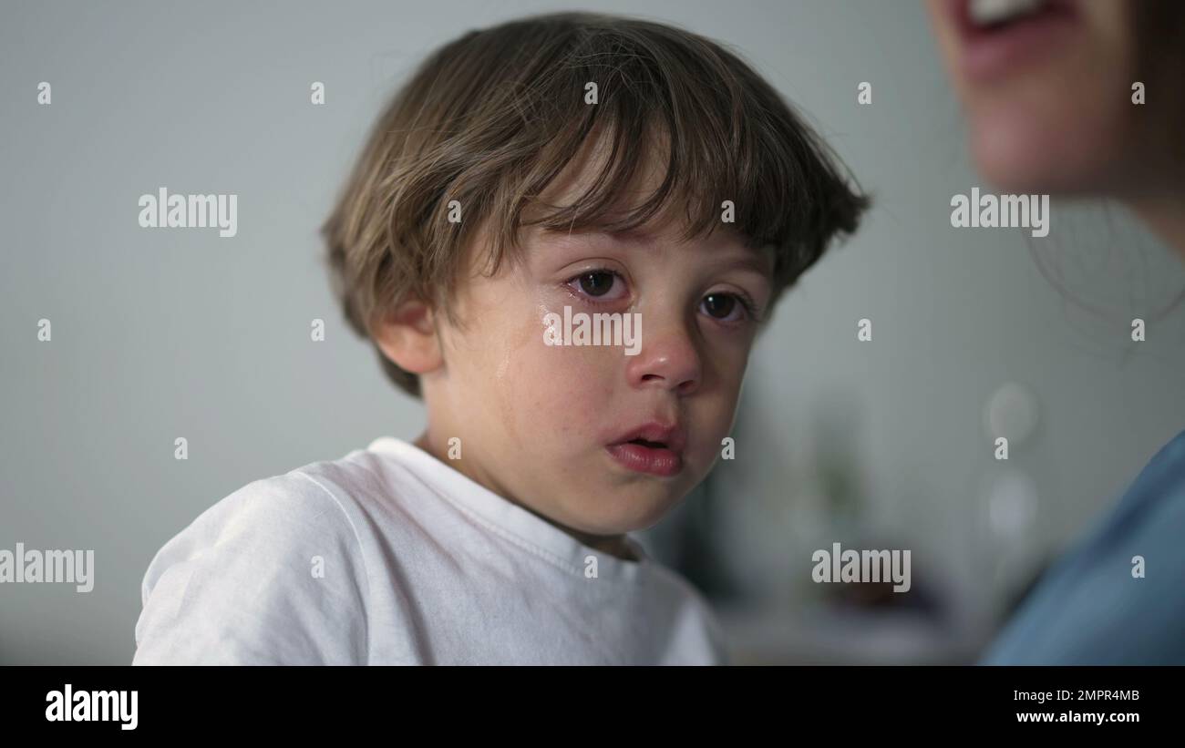 Portrait of a tearful child crying. Closeup face of a sad little boy. Authentic real life kid ...