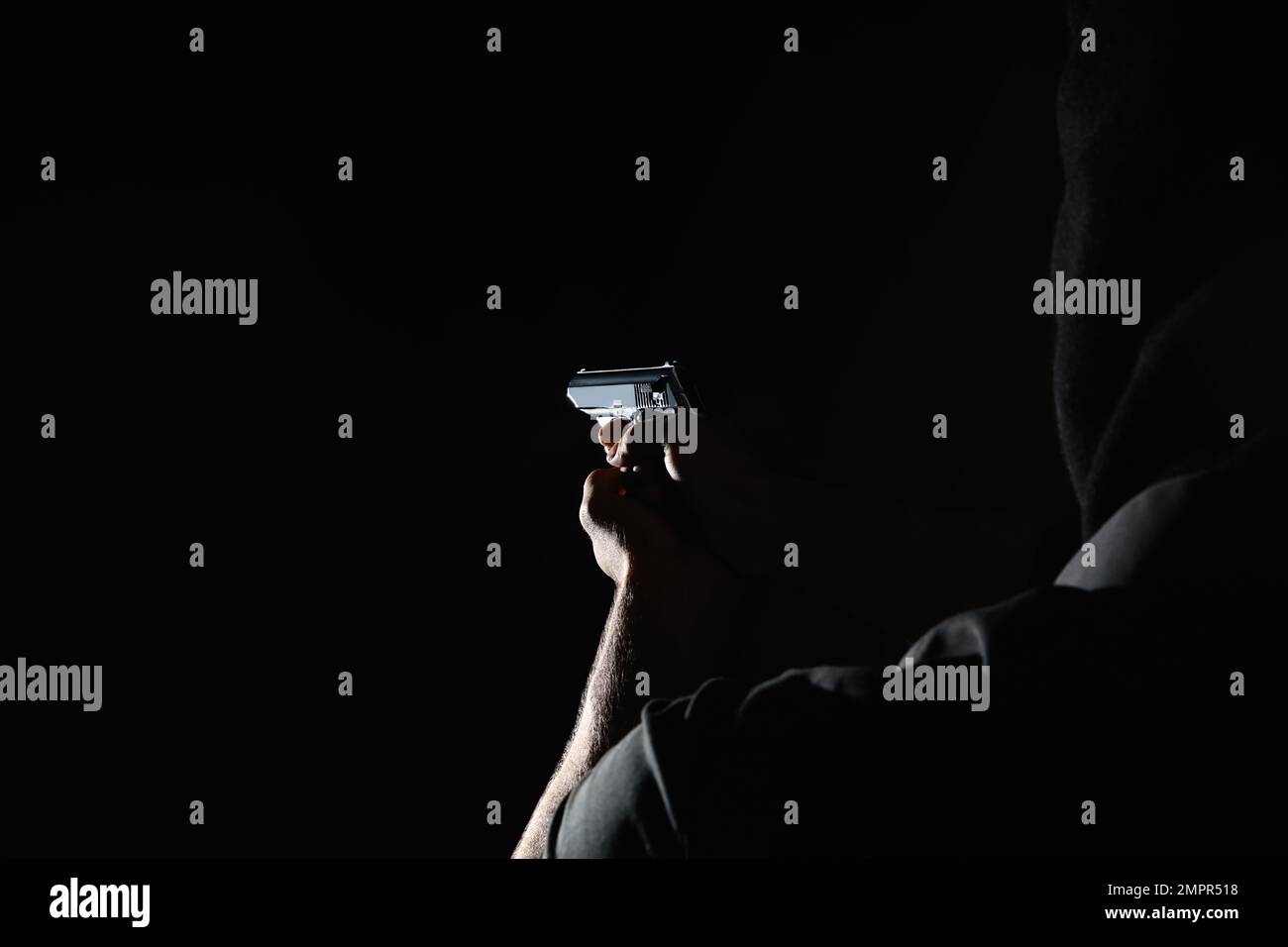 Professional killer with gun on black background, closeup Stock Photo ...