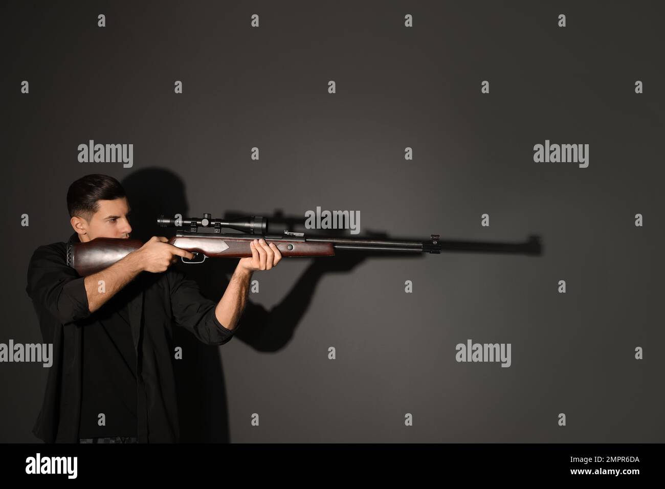 Professional killer with sniper rifle on black background Stock Photo ...