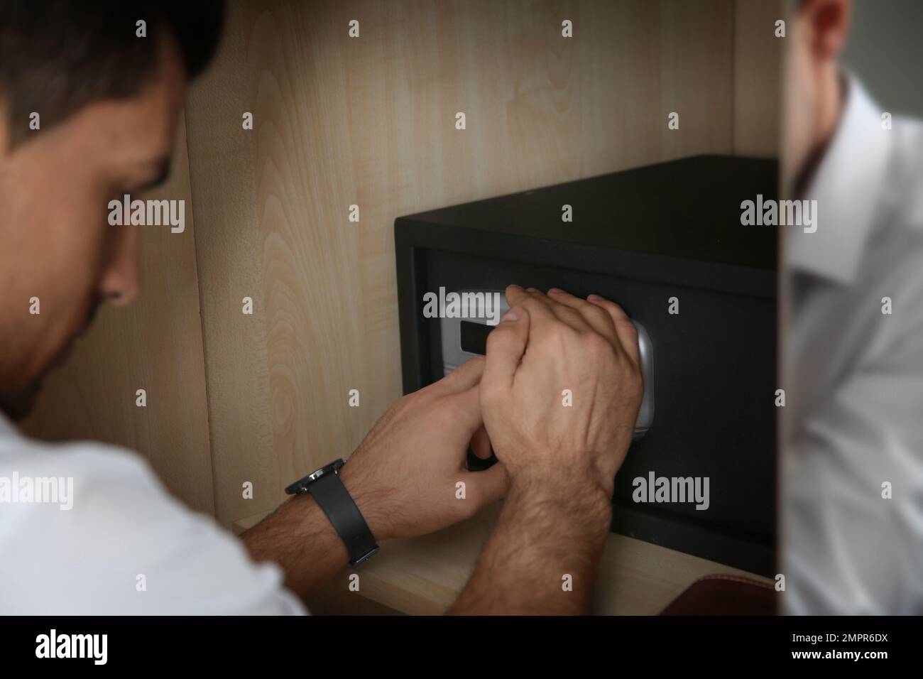 Man opening black steel safe with electronic lock at hotel, closeup ...
