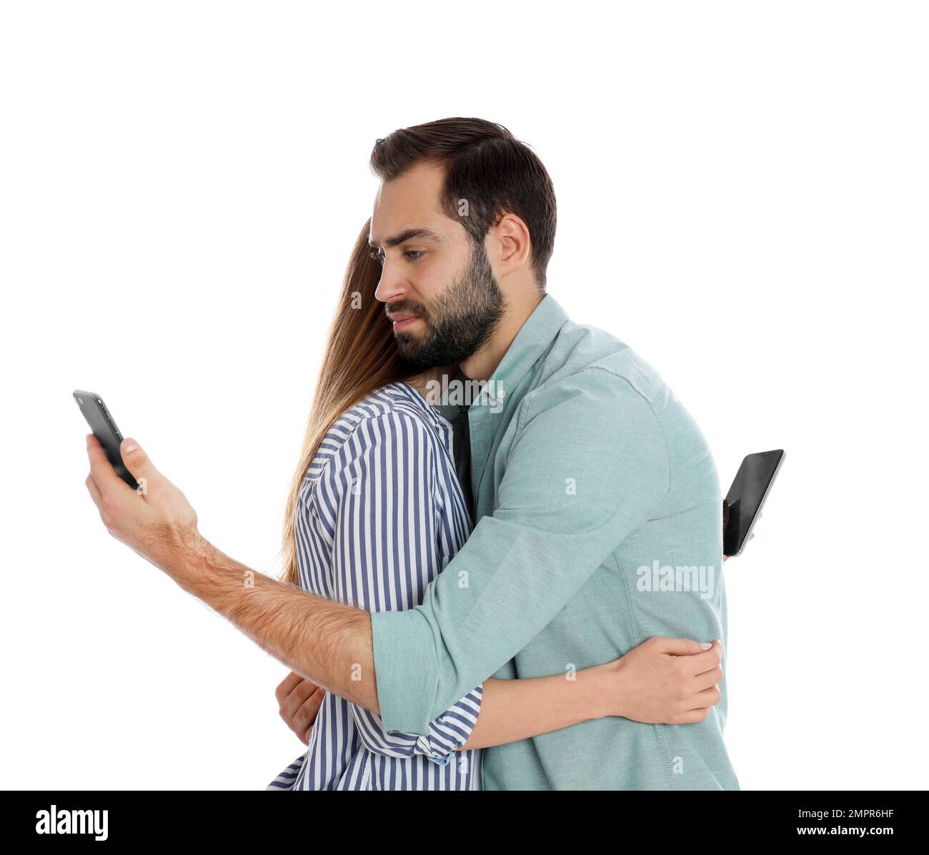 Couple addicted to smartphones hugging on white background ...
