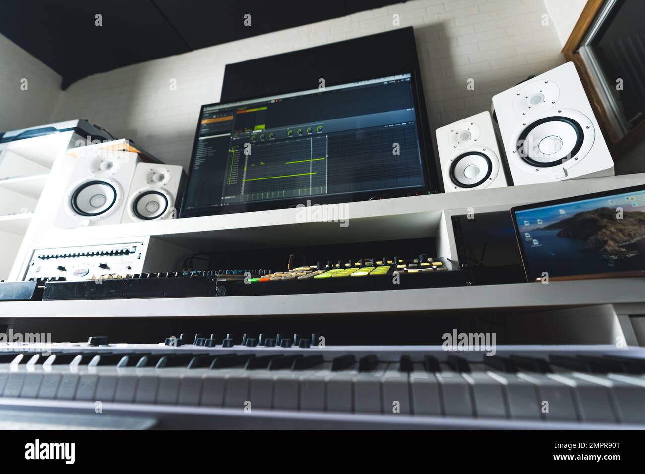 Music production desk with computer, synthsizer and sound mixer at home ...