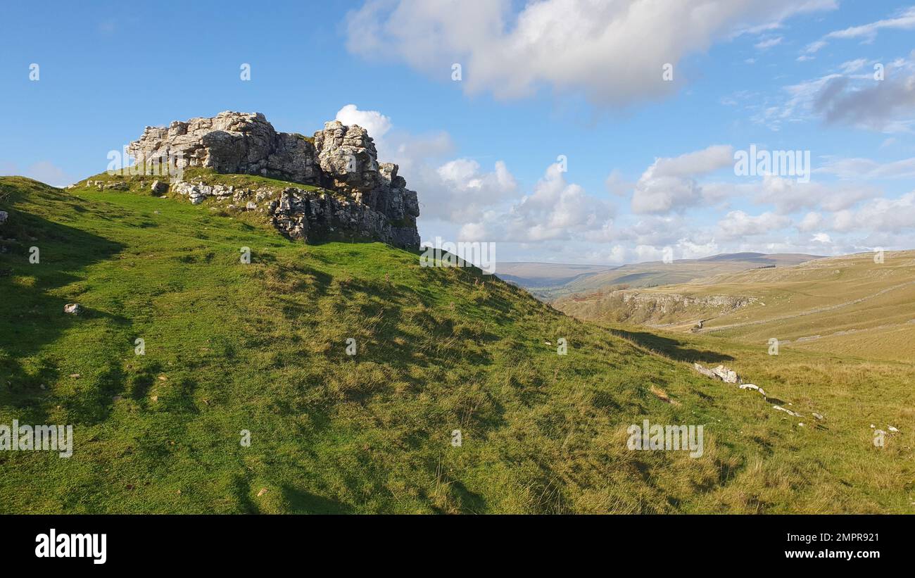 A view of Conistone Pie (limestone outcrop) on green hilltop ...